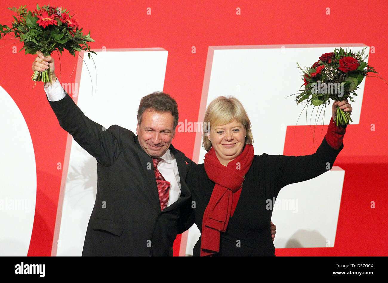 Incoming joint chairmen Gesine Loetzsch (R) and Klaus Ernst (L) cheer ...