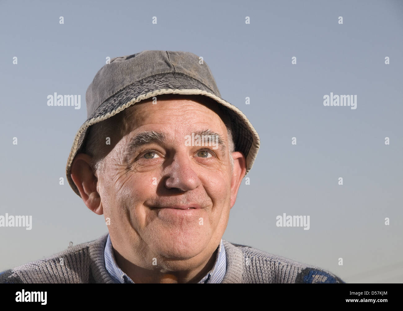 Man with hat looking up and a friendly expression Stock Photo - Alamy