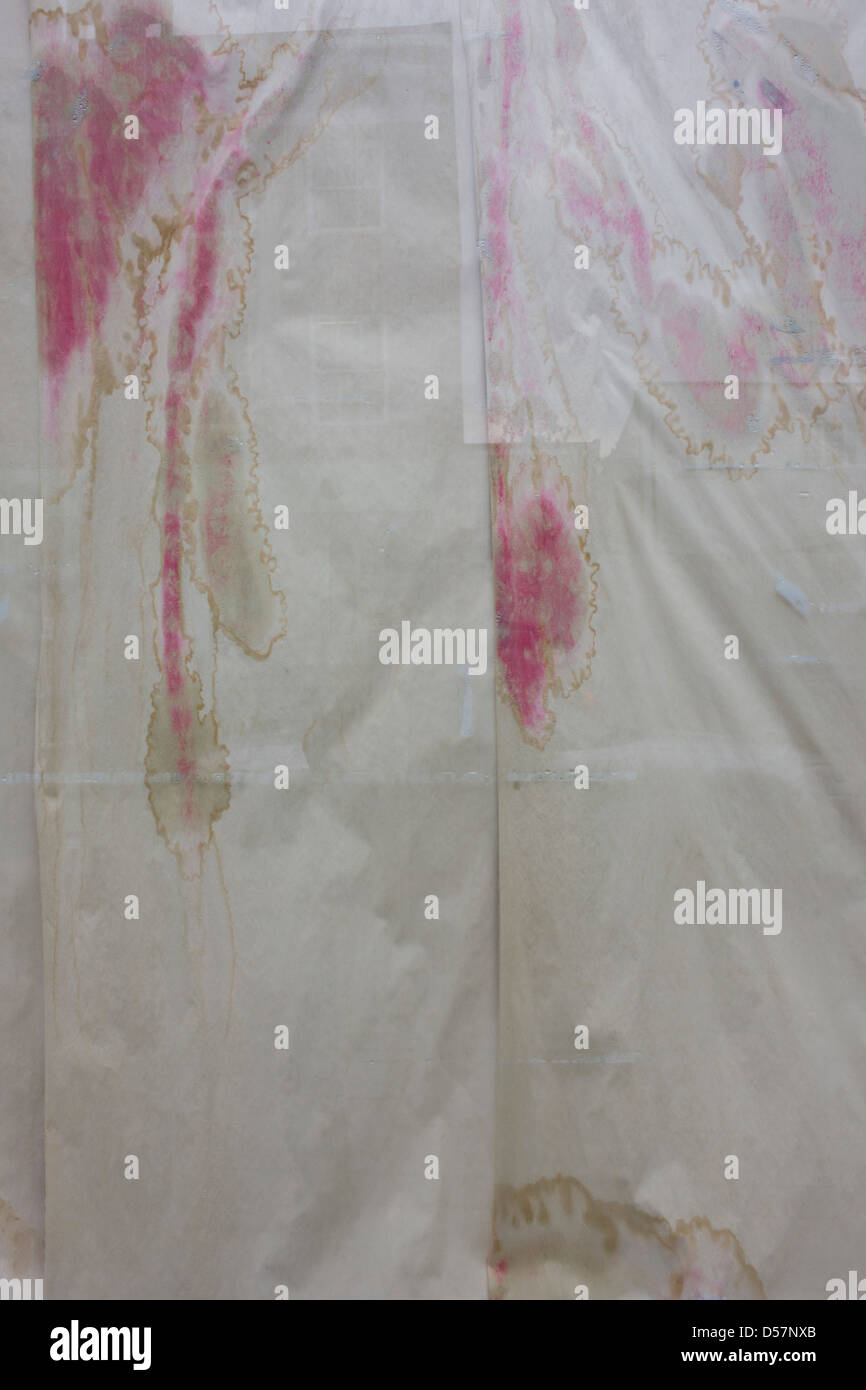 A CCTV security warning and damp stains on a card business window in an ...