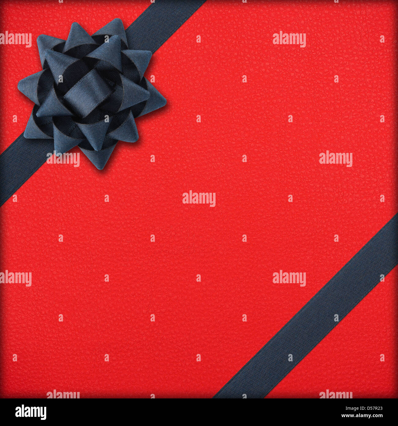 Dark bow and ribbon over red wrapped gift Stock Photo - Alamy