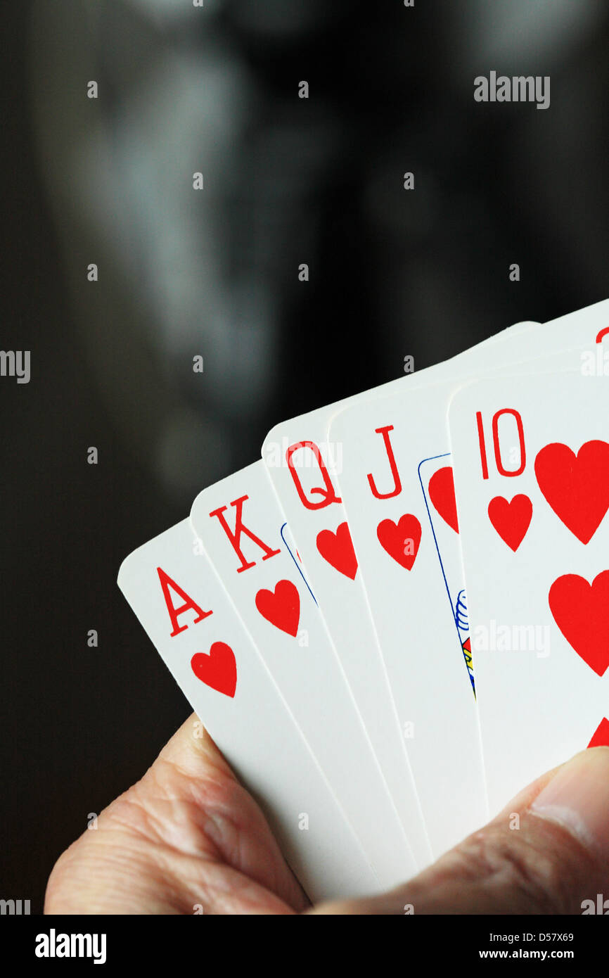 Holding royal flush in hearts, poker hand Stock Photo - Alamy