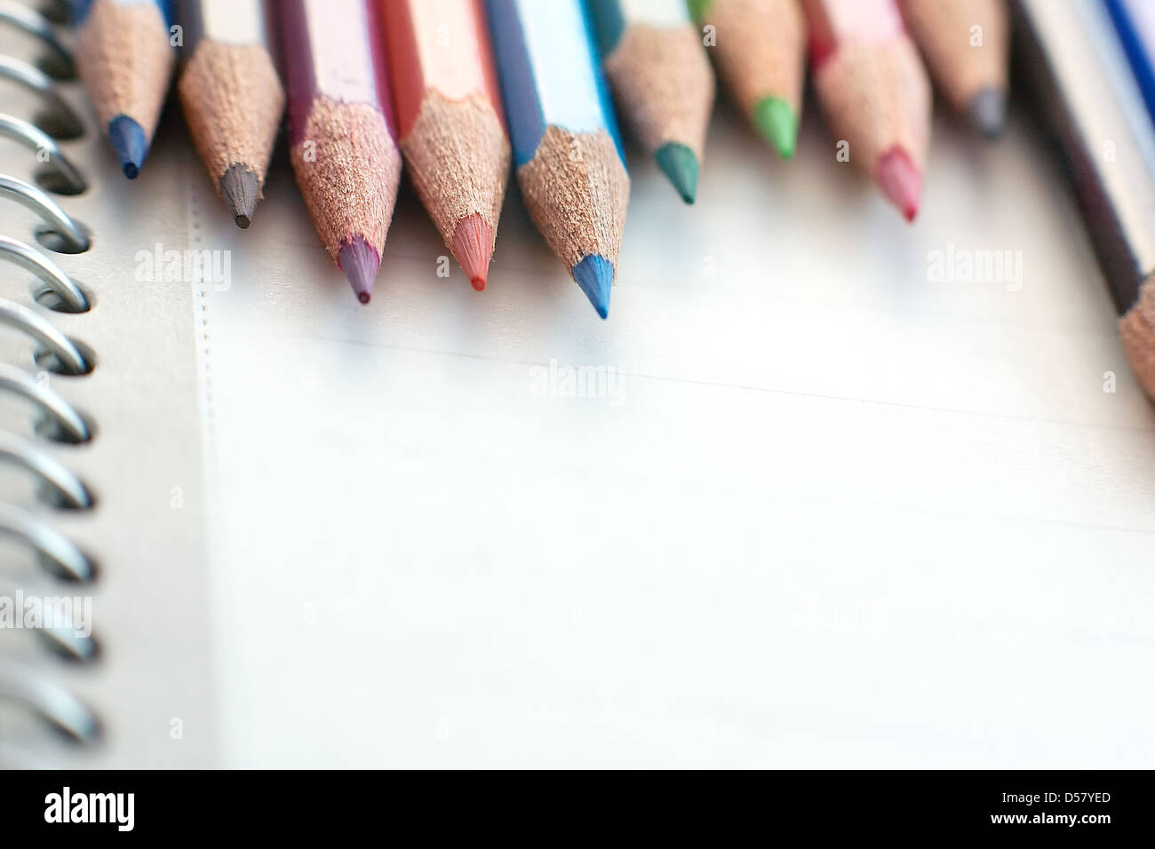 White notebook with colored pencils Stock Photo - Alamy