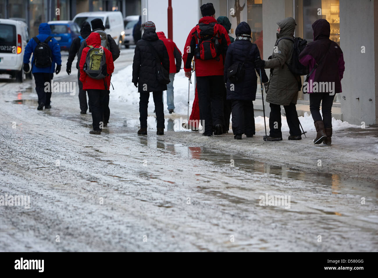 people walking along ice covered storgata main shopping street ...