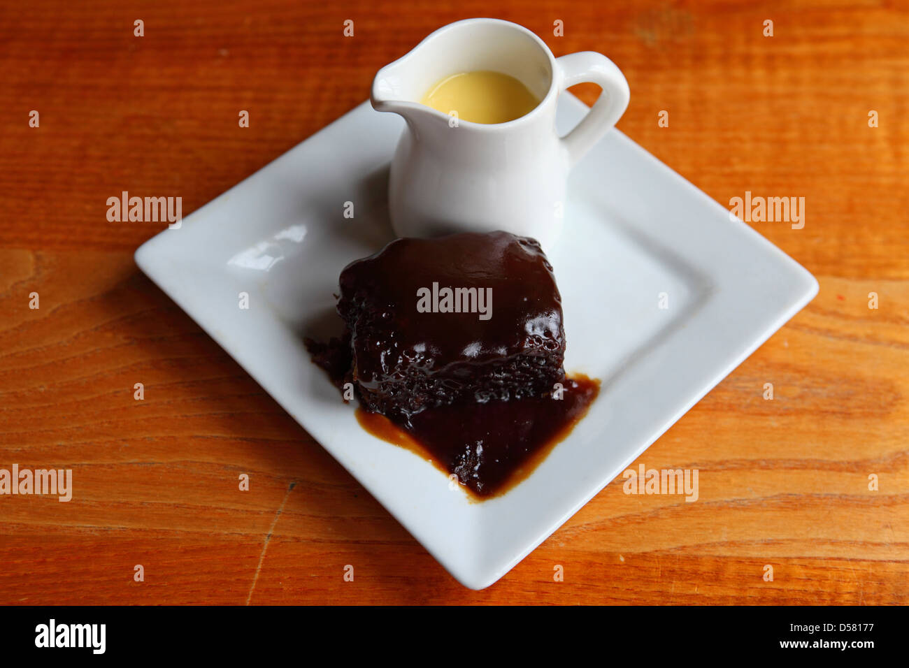 Sticky toffee pudding with a jug of custard Stock Photo - Alamy
