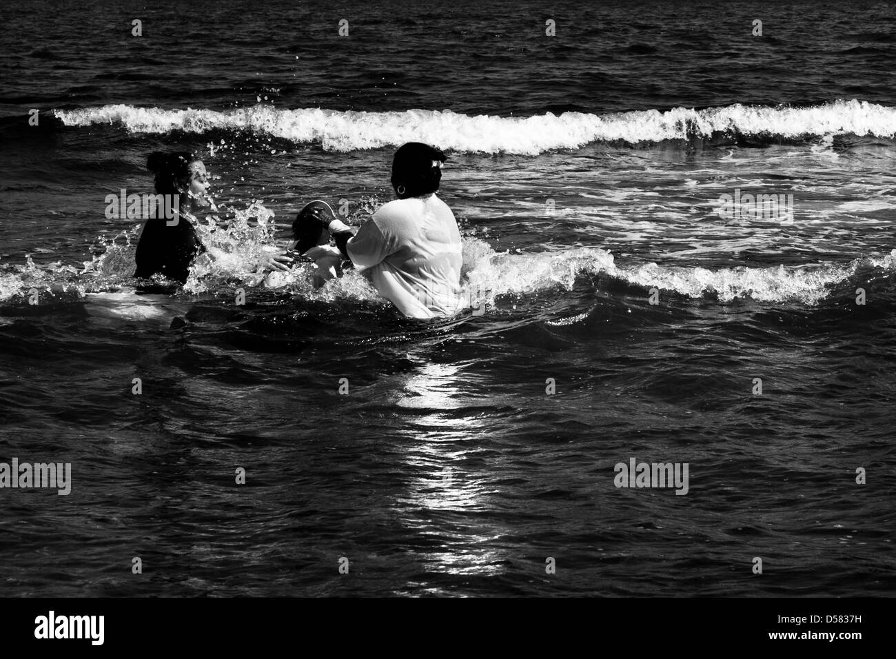 A Christian follower takes part in a baptism ritual in the waters of ...