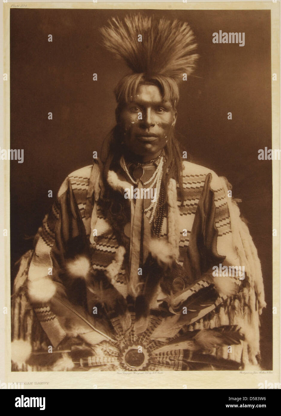 This early 20th-century photograph captures a Piegan man in traditional ...