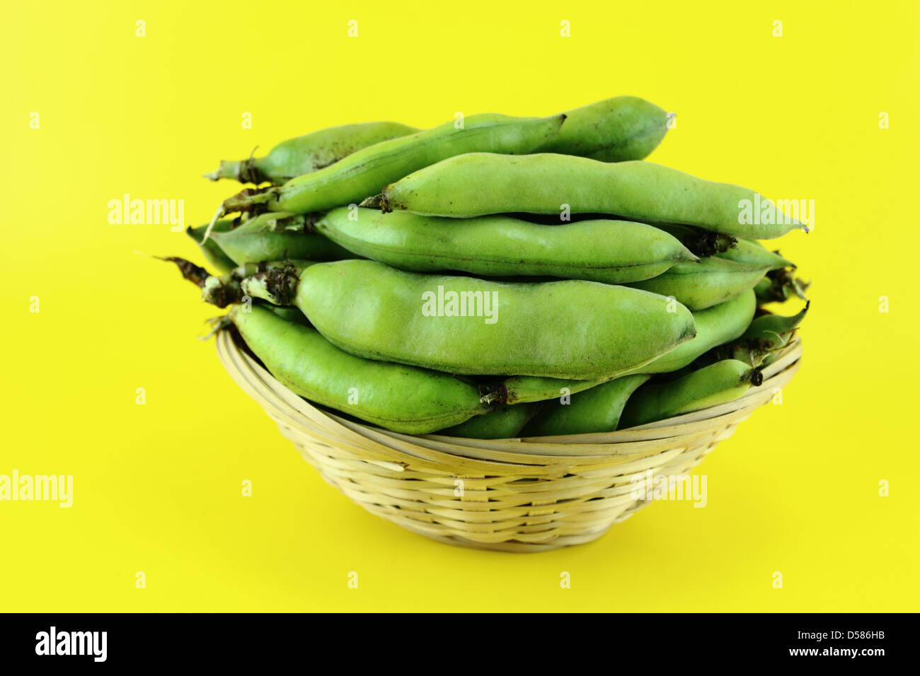 broad bean pods and beans on yellow background Stock Photo - Alamy