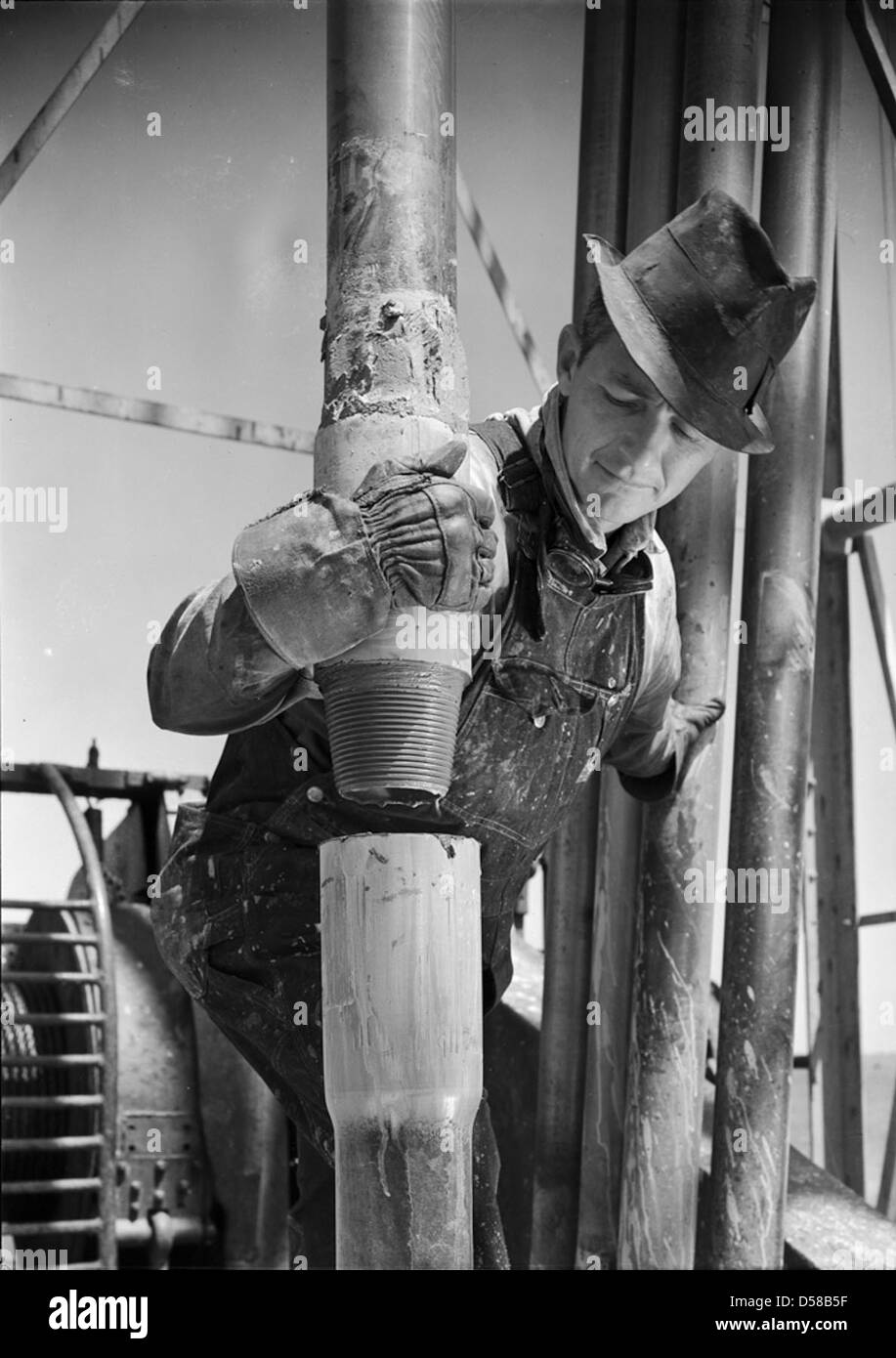 A historic photograph of roughnecks working at a drilling site for ...