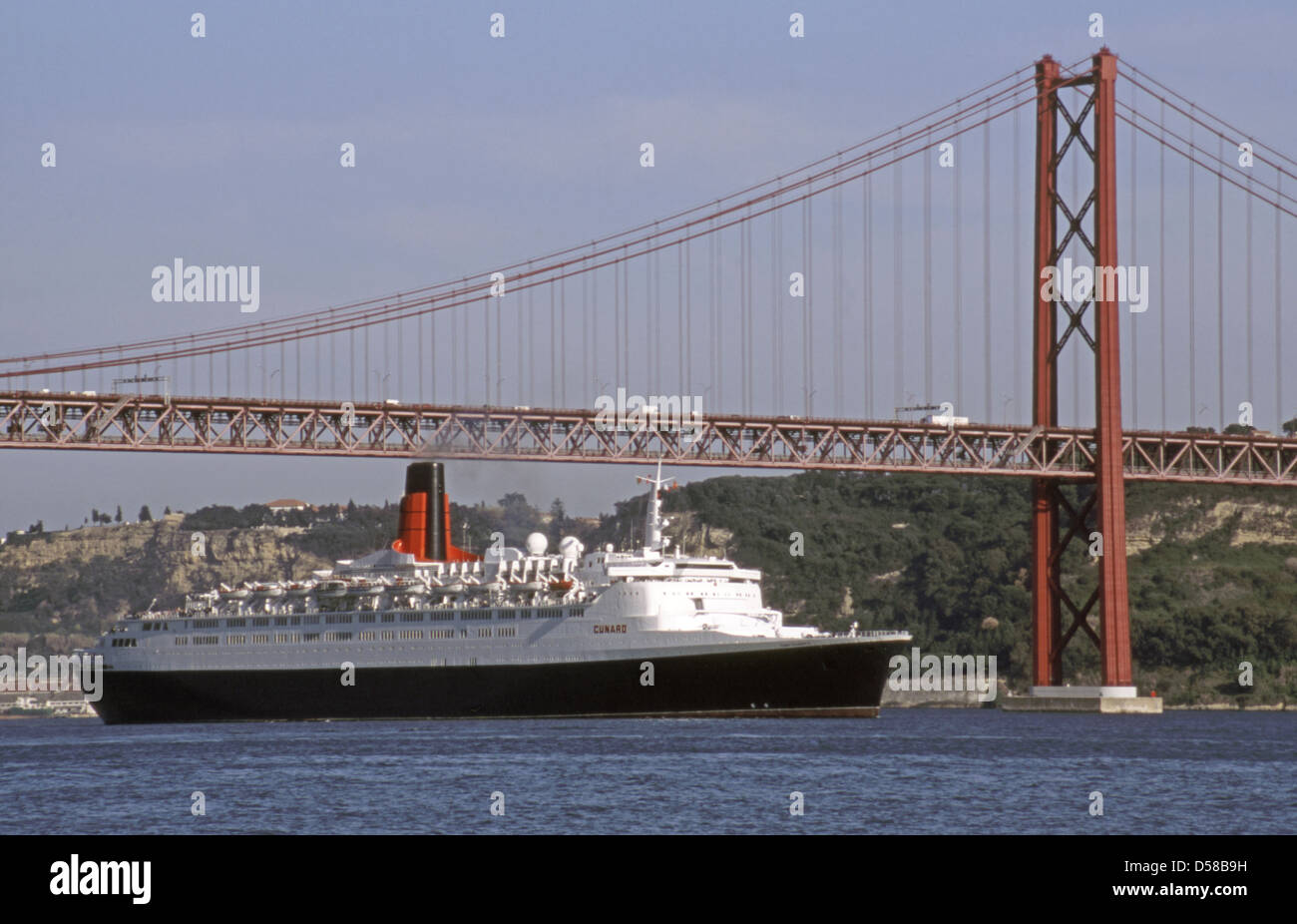 The QE2 passenger cruise liner passes under the 25 de abril bridge in ...