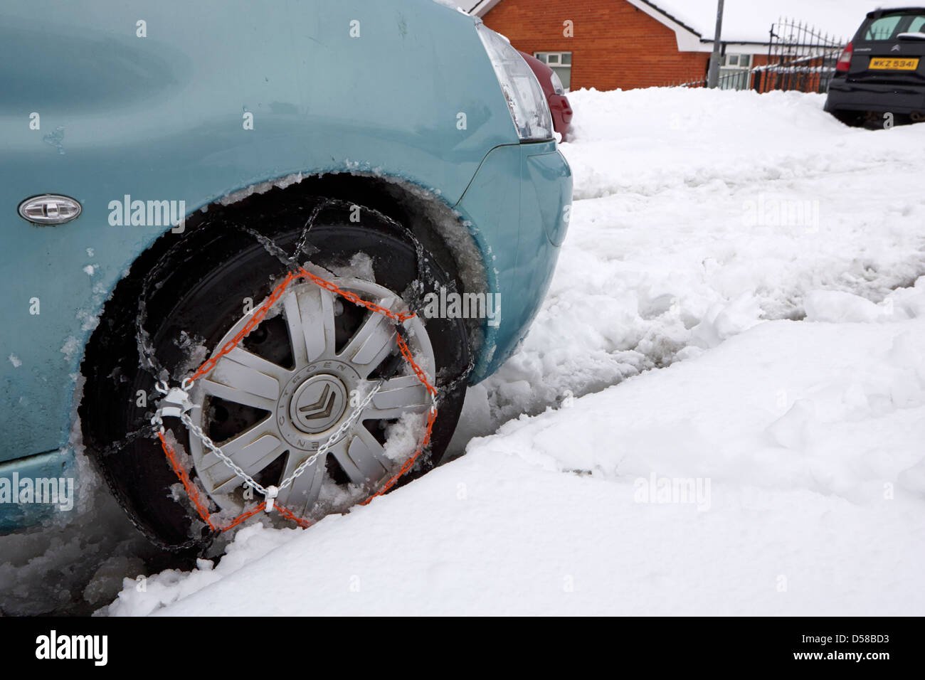 road vehicle with snowchains fitted to car in heavy winter snowstorm ...