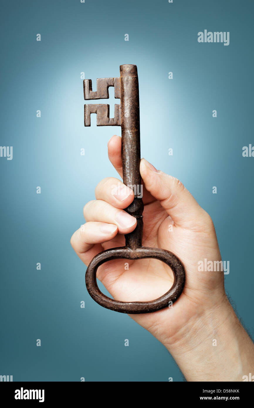Man holding a big antique skeleton key in his hand Stock Photo - Alamy