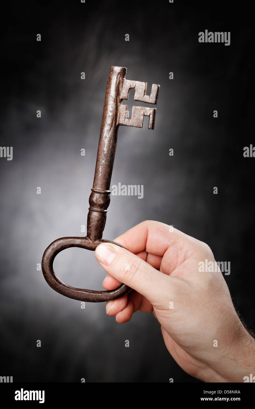 Man holding big old antique key in his hand Stock Photo - Alamy