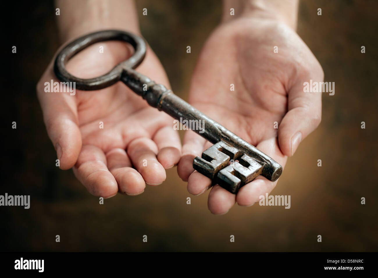 Man holding a big old antique skeleton key in his hands. Very short ...