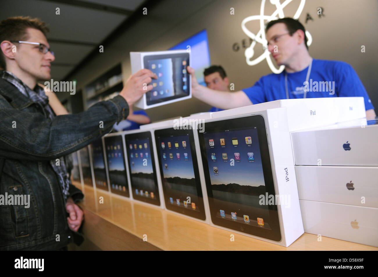 An employee hands an iPad to a customer at the Apple store in Munich ...