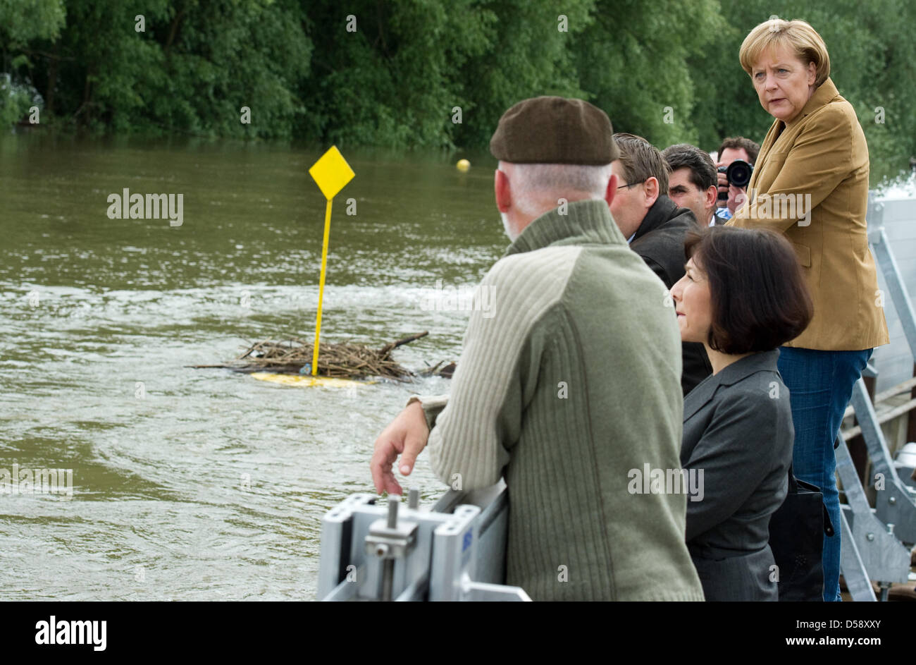 German Chancellor Angela Merkel (top) checks out the high water of the ...