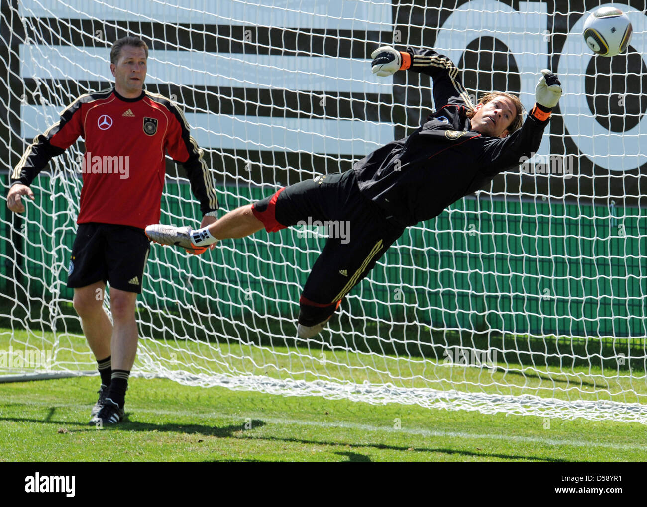 Germany's goalkeeper Tim Wiese (R) jumps after a ball next to ...