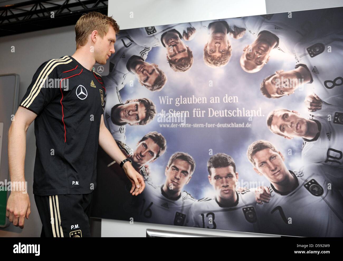 Defender Per Mertesacker of Germany walks past a team photo of the ...