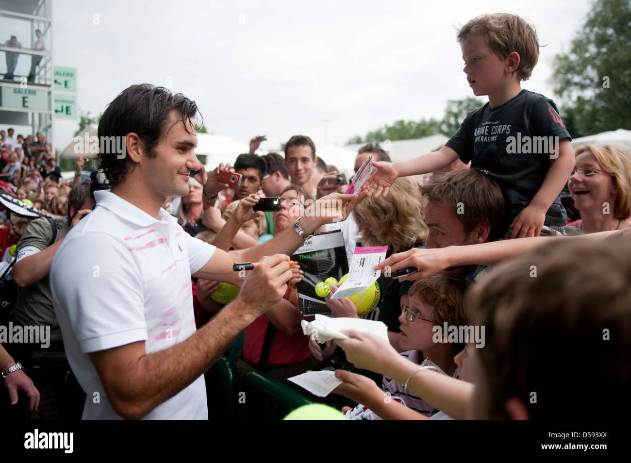 Switzerland's Roger Federer signs autographs after winning his round of ...