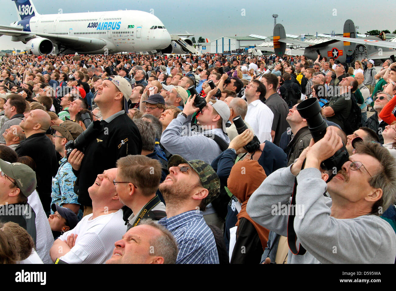 Visitors of the flight show stand close together in front of an Airbus ...