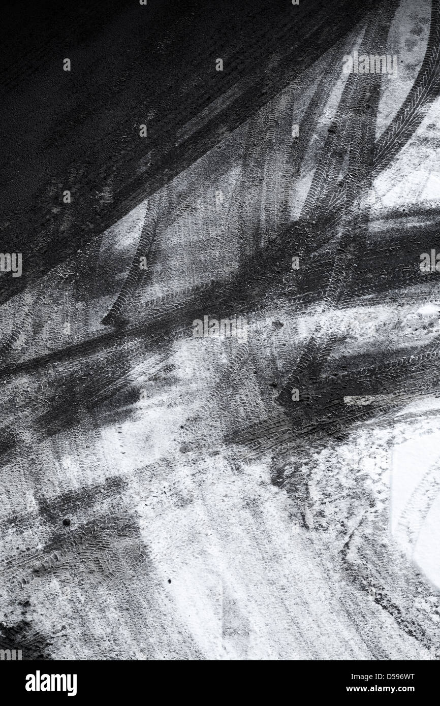 Abstract background texture of asphalt road covered with snow and tire ...