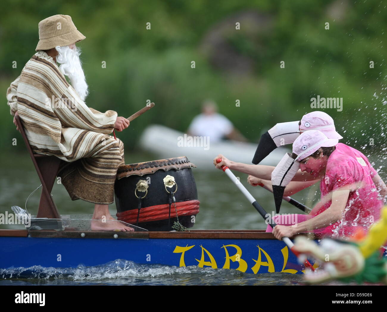 Paddlers in costumes participate in a dragon baot race on the Main ...