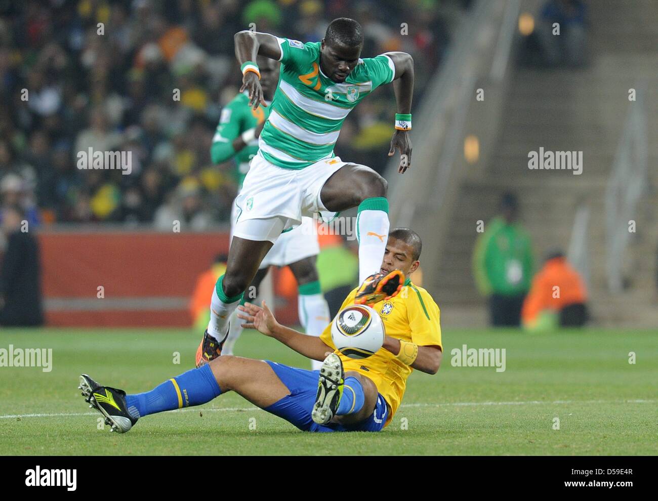 Ivory Coast's Emmanuel Eboue steps over Brazil's Felipe Melo during the ...