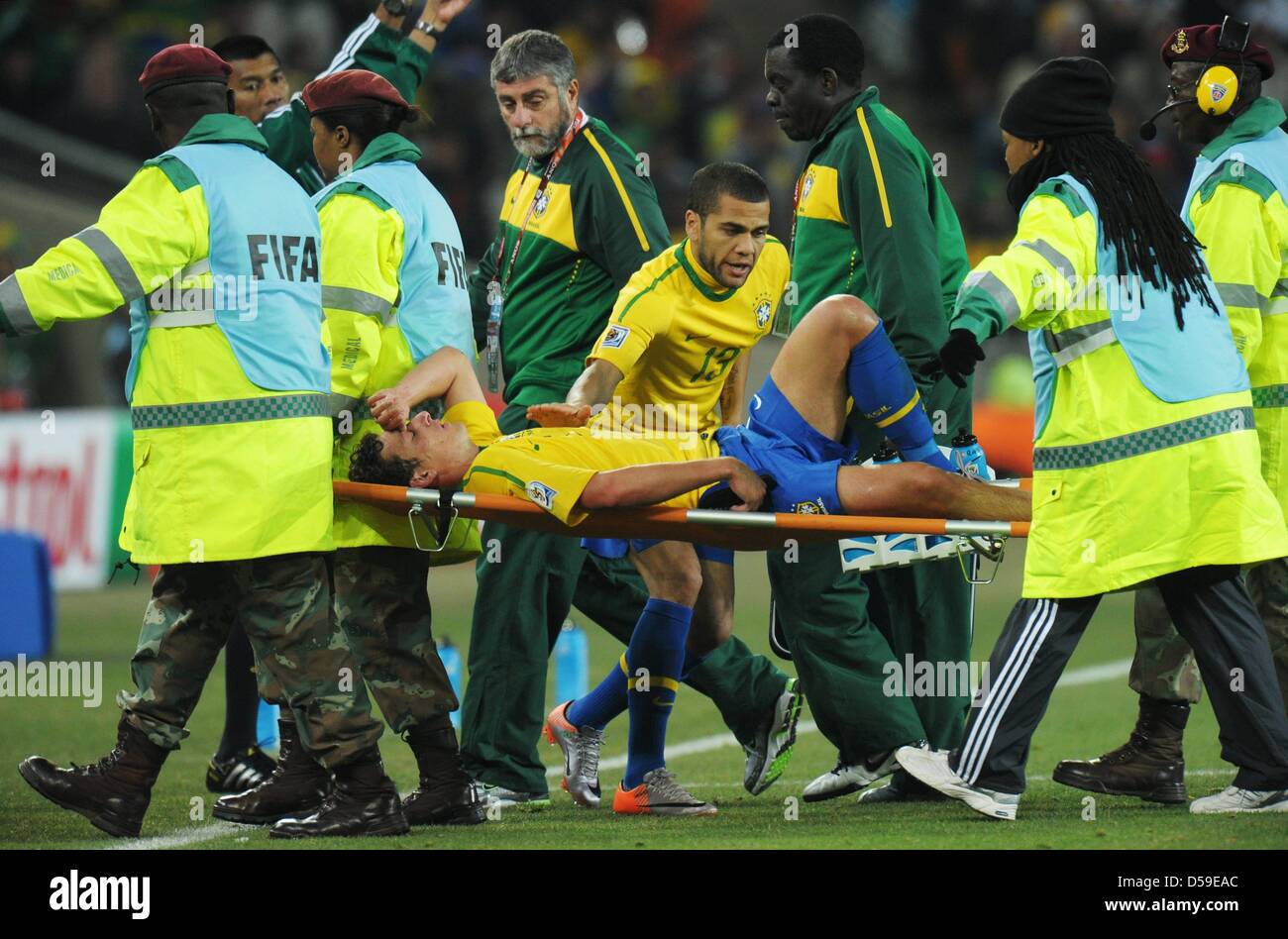 Elano of Brazil is being carried off pitch next to his teammate Dani ...