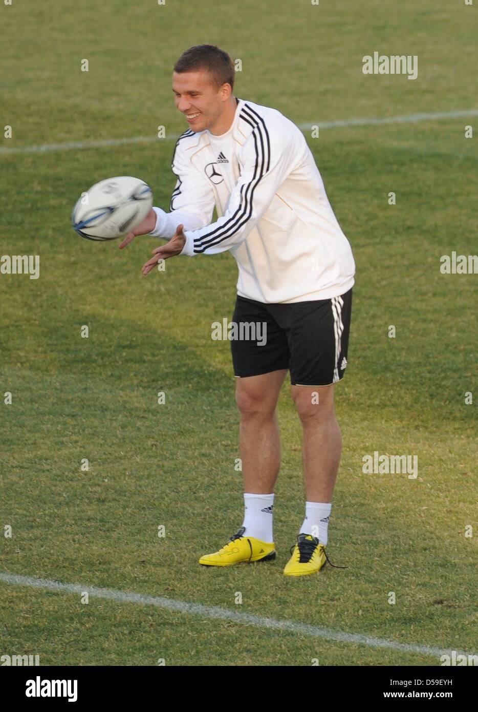 Germany's Lukas Podolski catches a rugby during a training session of ...