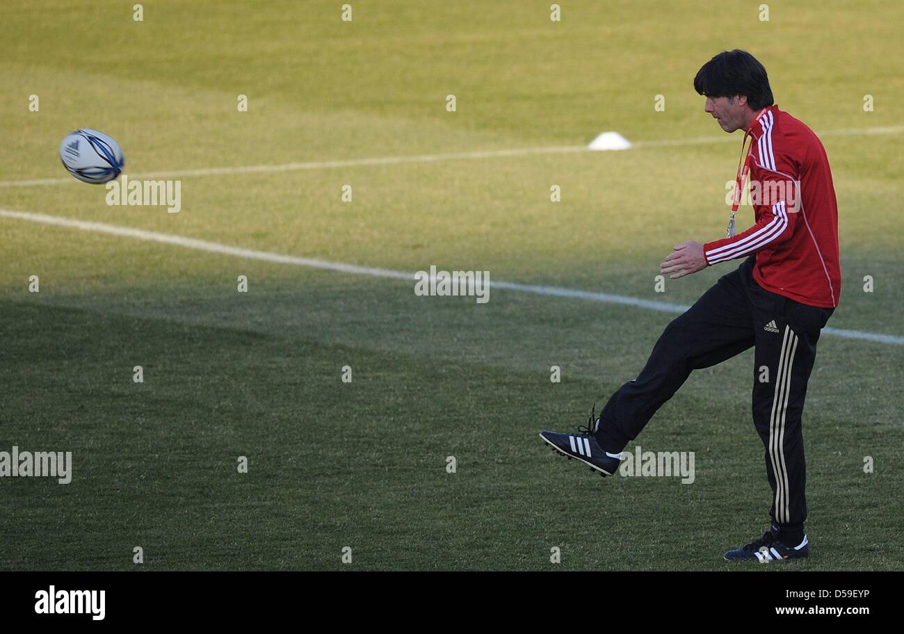 Germany's coach Joachim Loew kicks a rugby during a training session of ...