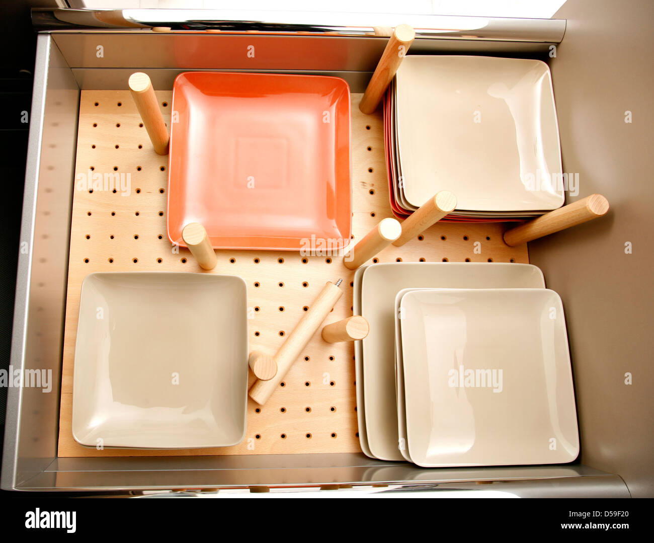 Drawer for dishes containing colourful square plates Stock Photo - Alamy