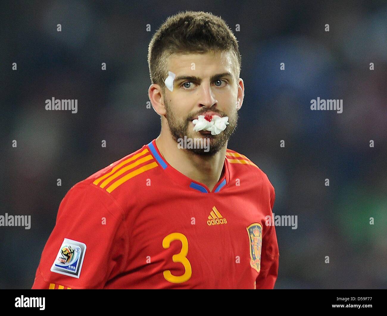 Spain's Gerard Pique holds a bloody handkerchief between his lips ...