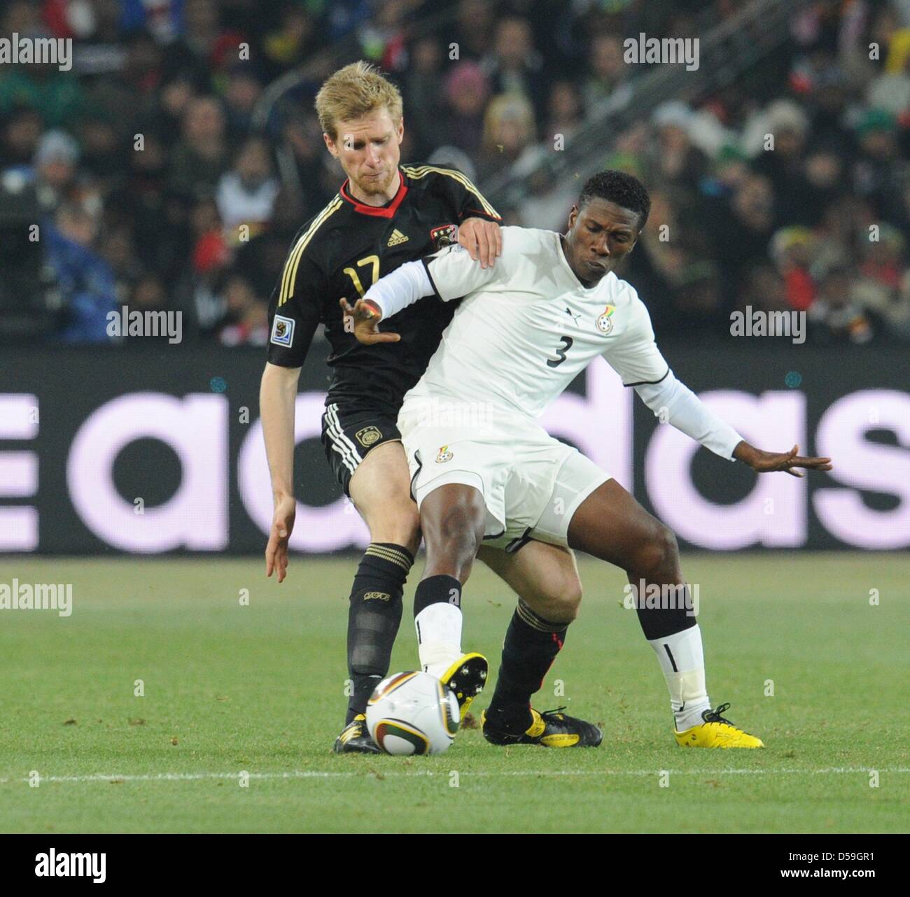 Asamoah Gyan (R) of Ghana vies with Per Mertesacker of Germany ...