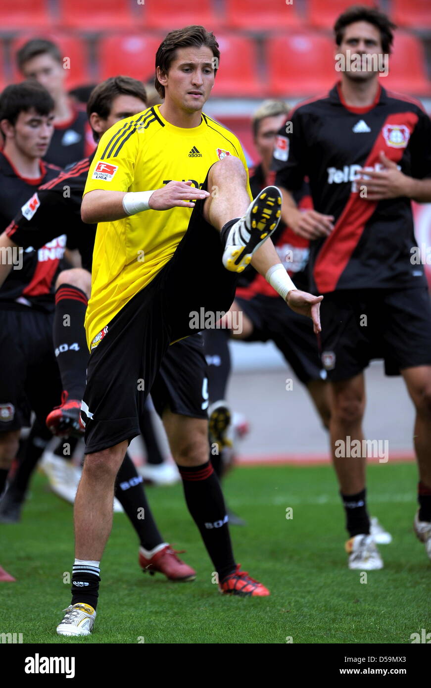 Bayer Leverkusen's Rene Adler (L) and Manuel Friedrich warm themselves ...