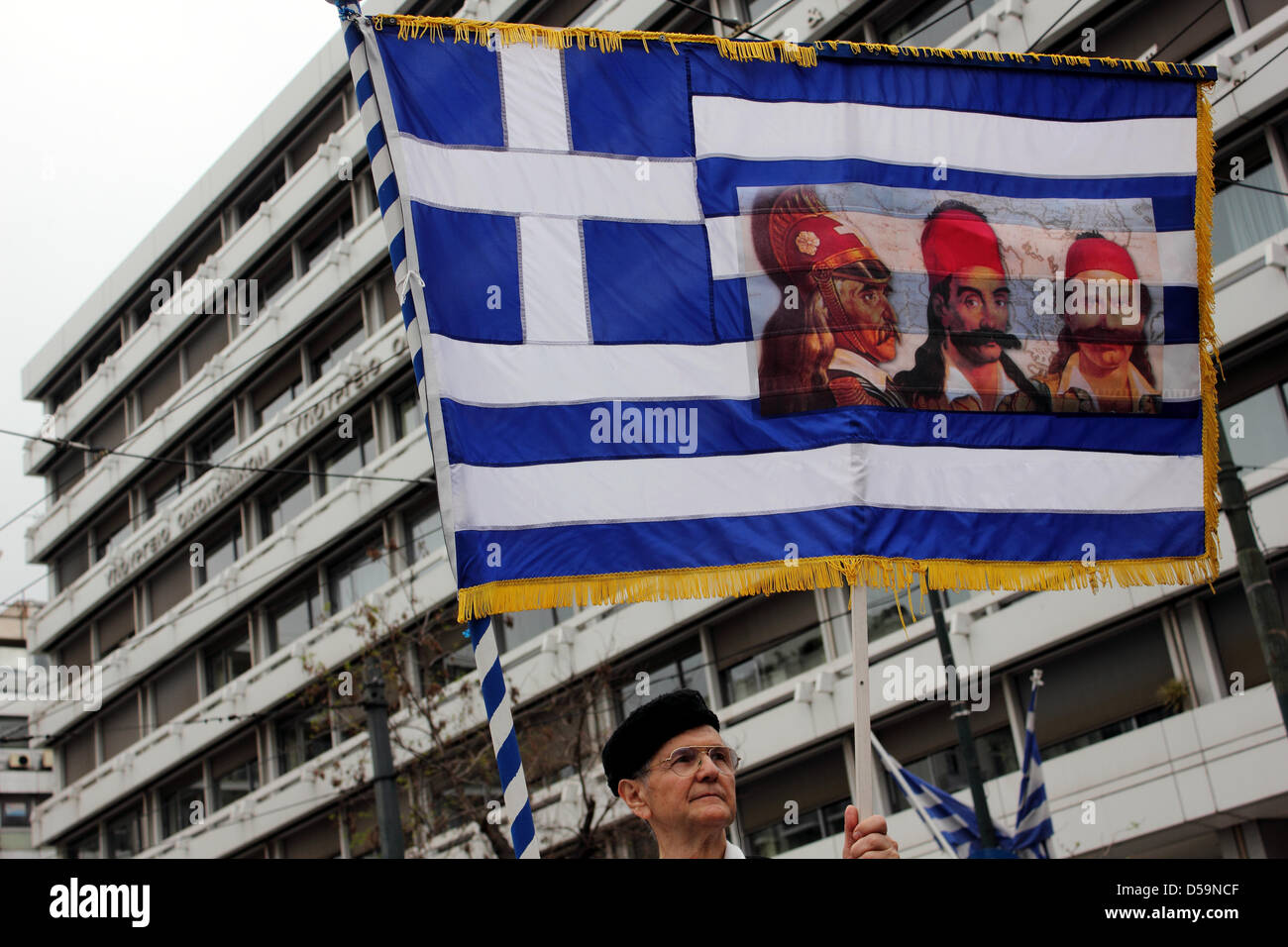 Greek pensioner with flag of Greek Freedom fighters in front of ...