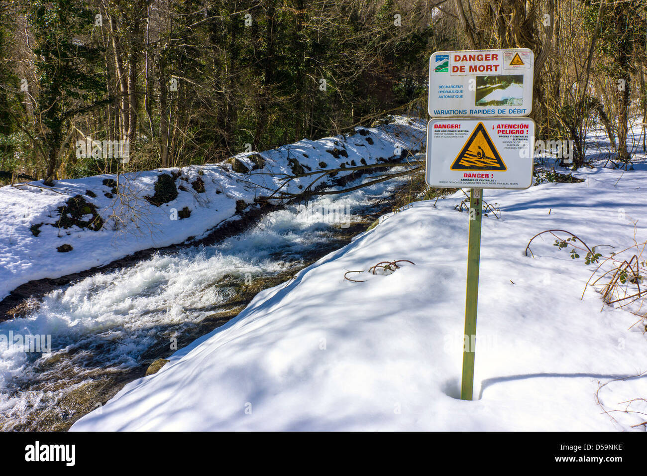 Warning sign by overflow flood channel with snow Stock Photo - Alamy