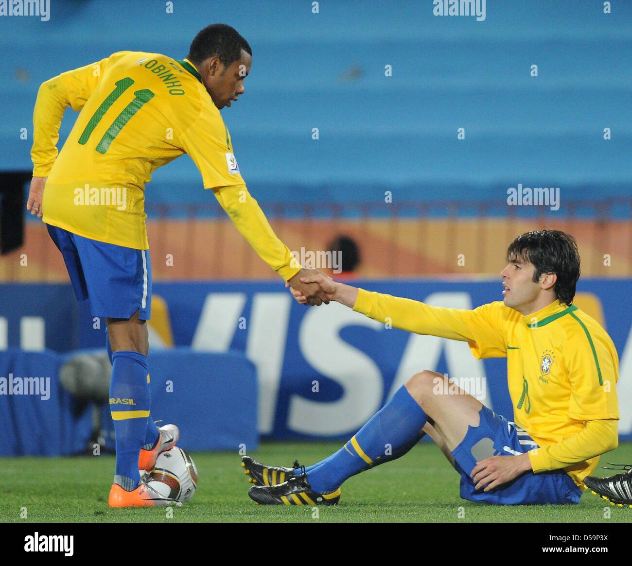 Brazil's Kaka (R) is helped up by team mate Robinho during the 2010 ...