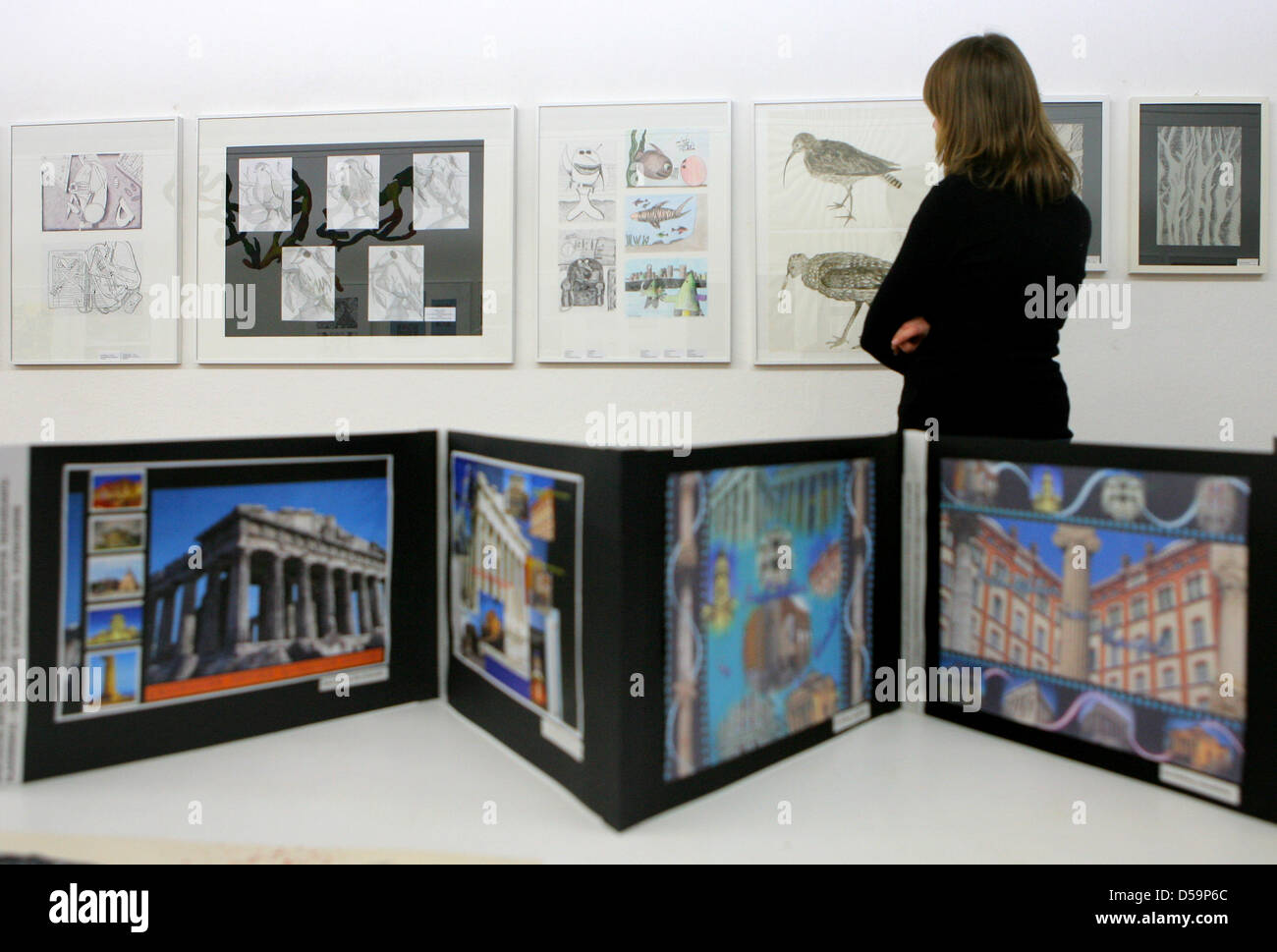 A visitor looks at objects featured in the exhibition 'Pupils exhibit ...