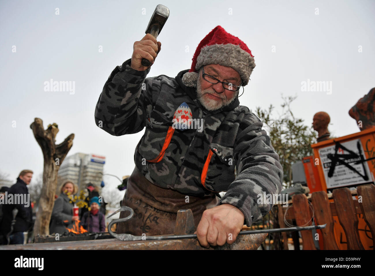 Artisan smith Michael Soika forges a piece of iron with a hammer at the ...