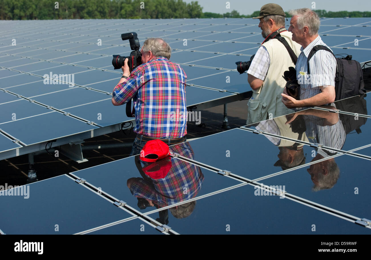 Photographers take pictures of newly installed solar panels on the roof ...