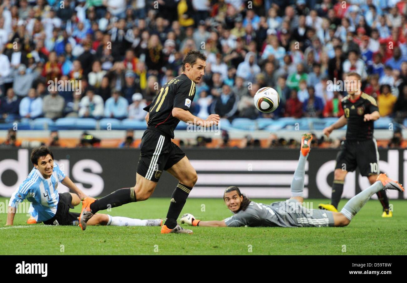 Miroslav Klose (C) of Germany scores against Nicolas Burdisso (L) and ...