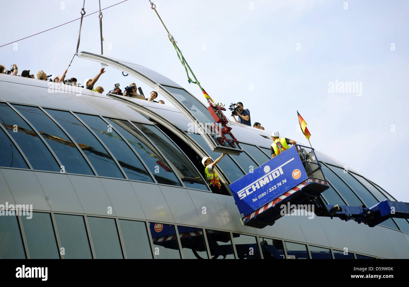 Workers insert the last piece of facade into the Airrail Center's ...