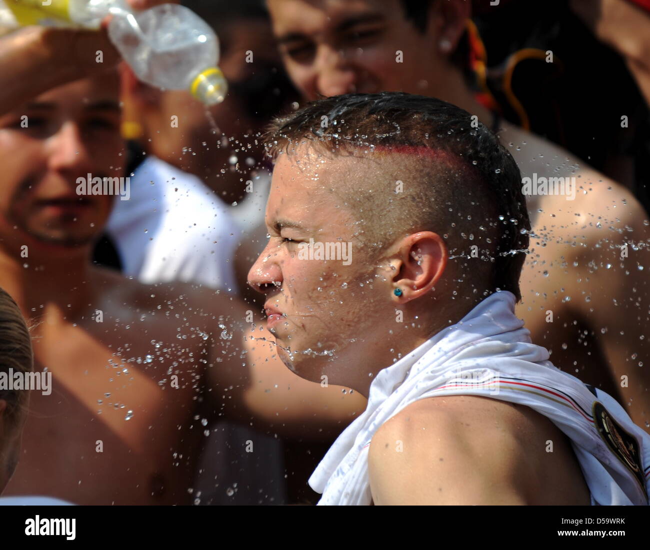 A soccer fan seeks refreshment by dripping water ontop of his head in ...