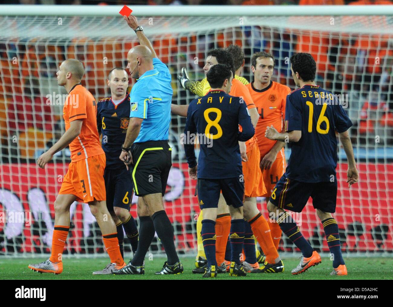 Referee Howard Webb (3-L) shows John Heitinga (L) of the Netherlands ...