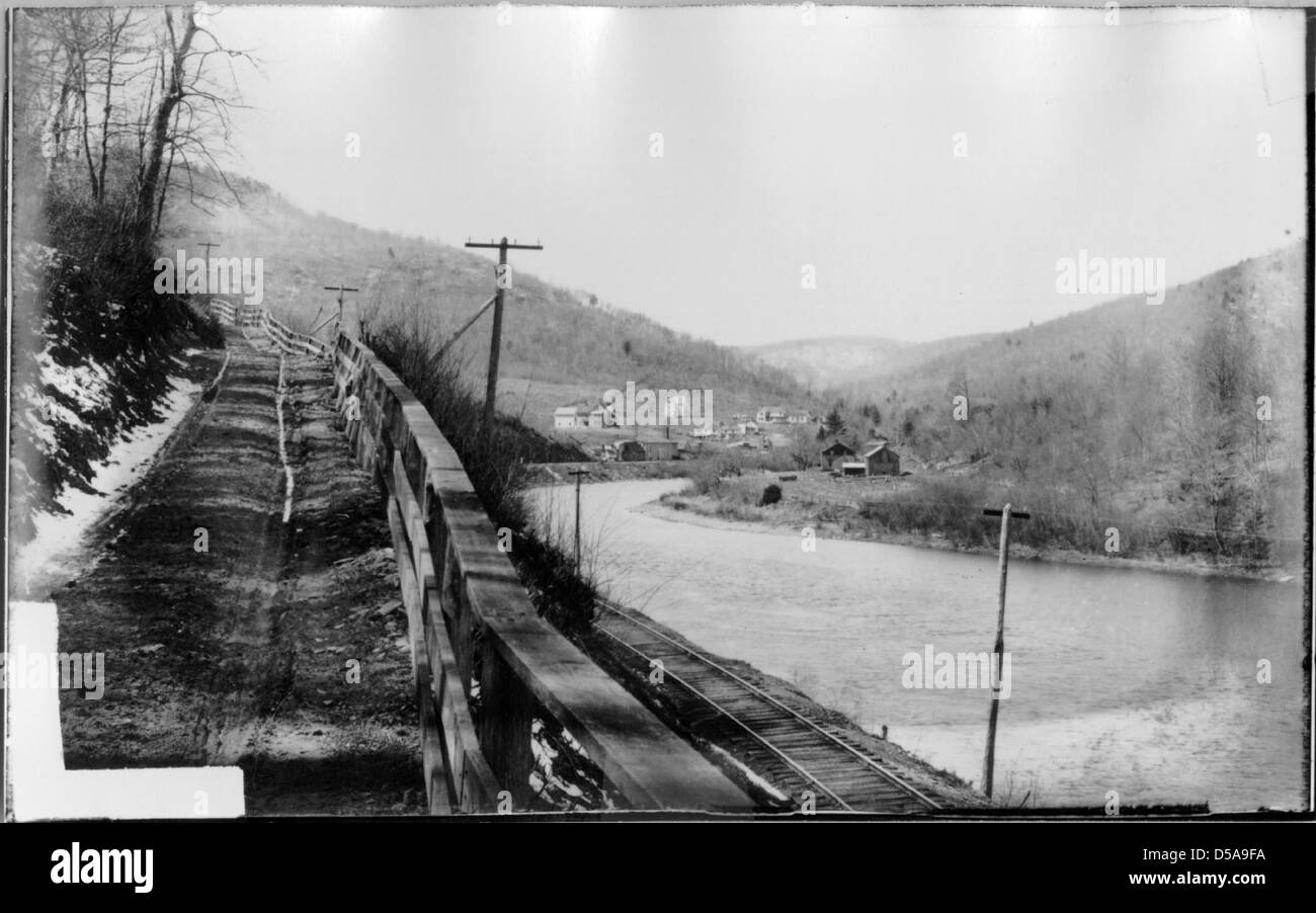 A photograph of a railroad track running along a river, emphasizing the ...