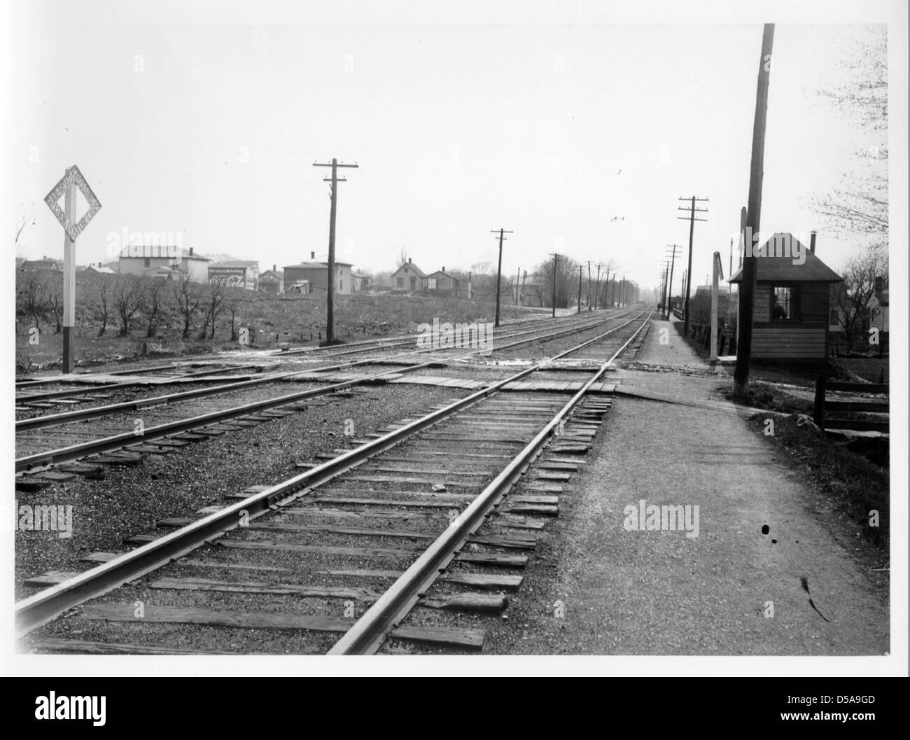 This image shows two railroad tracks intersecting with a shed, a ...