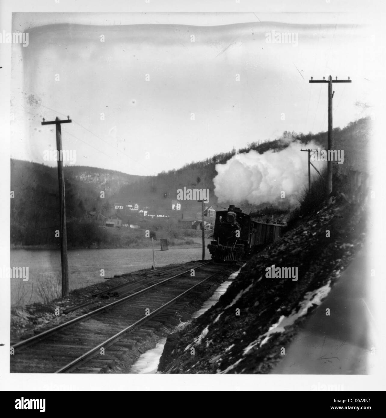 A historical photograph of a locomotive coming around a bend. The image ...