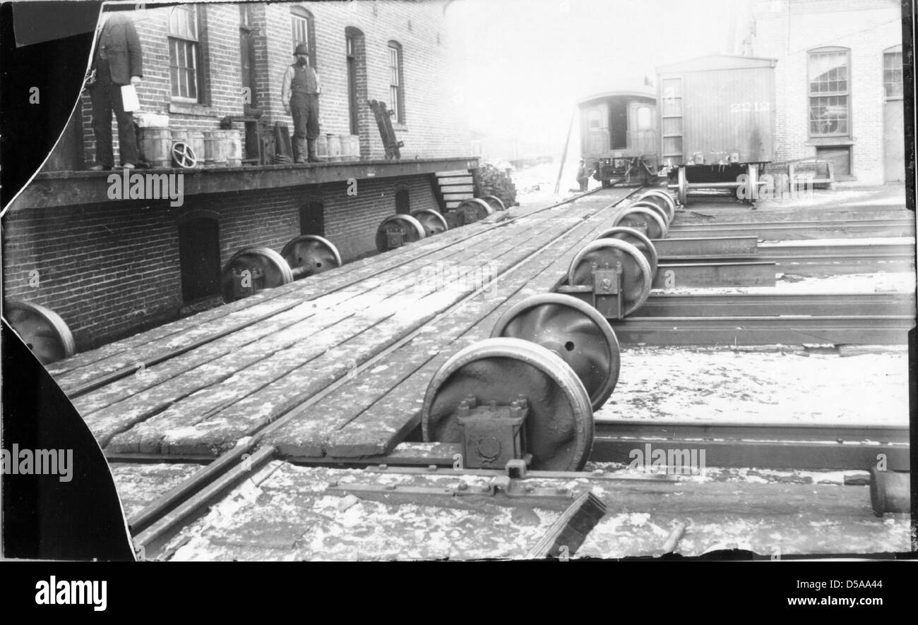 This image depicts workers and a transfer table, likely associated with ...
