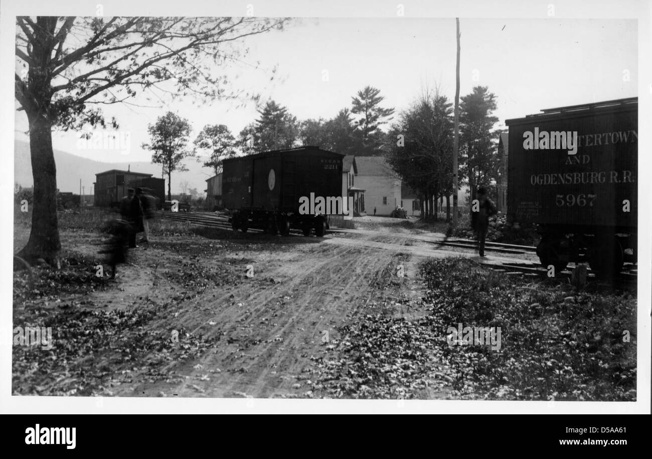 A historical photograph showing a railroad crossing with two freight ...