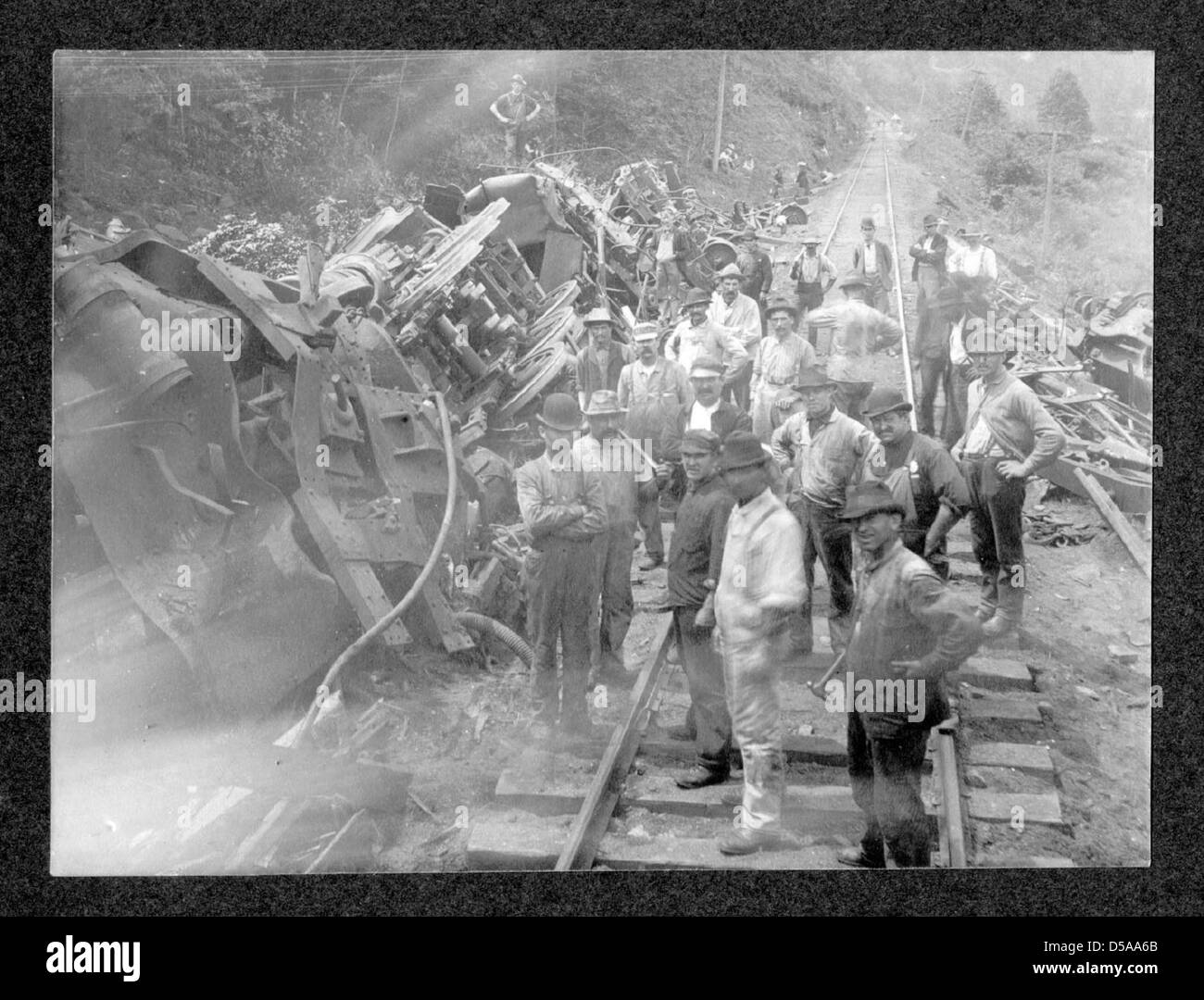 This photograph shows a railroad accident being cleared off the tracks ...
