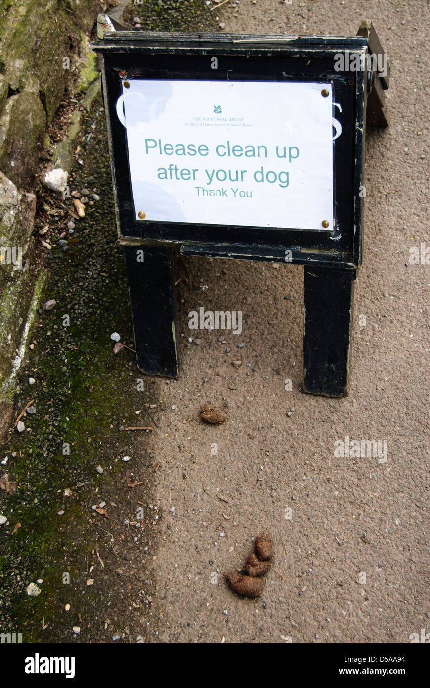 Sign to clean up dog poop with poop next to sign on the street Stock ...
